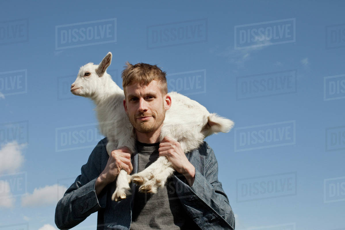 A man carrying a kid goat on his shoulders - Royalty-free Stock Photo ...