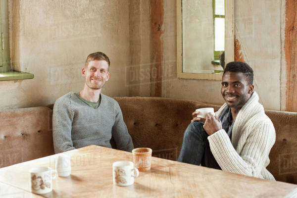 Two friends sitting at table - Stock Photo - Dissolve