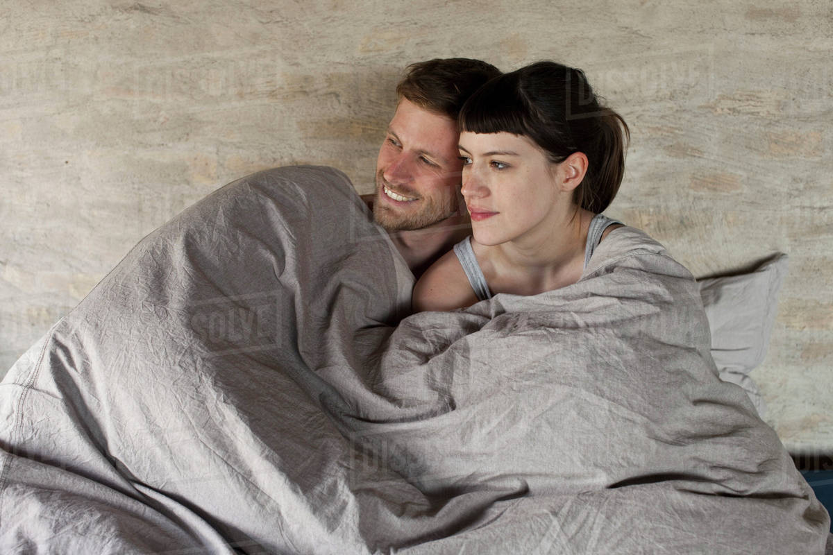 A couple snuggling in bed - Royalty-free Stock Photo | Dissolve