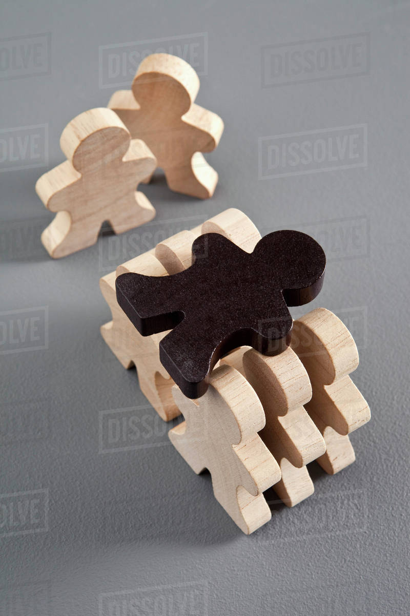Six unpainted wooden stick figures carrying a brown wooden stick figure ...