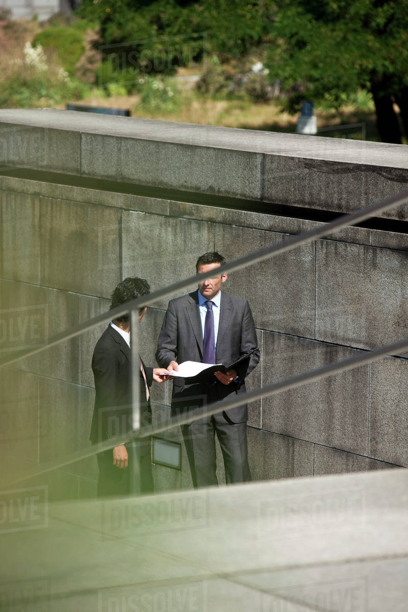 Two businessmen conducting suspicious business - Stock Photo - Dissolve
