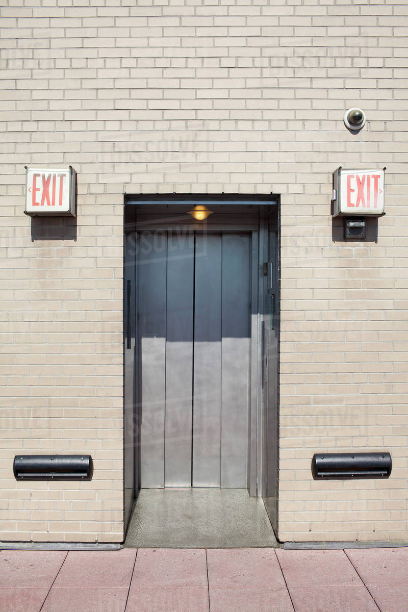 An elevator between two EXIT signs - Stock Photo - Dissolve