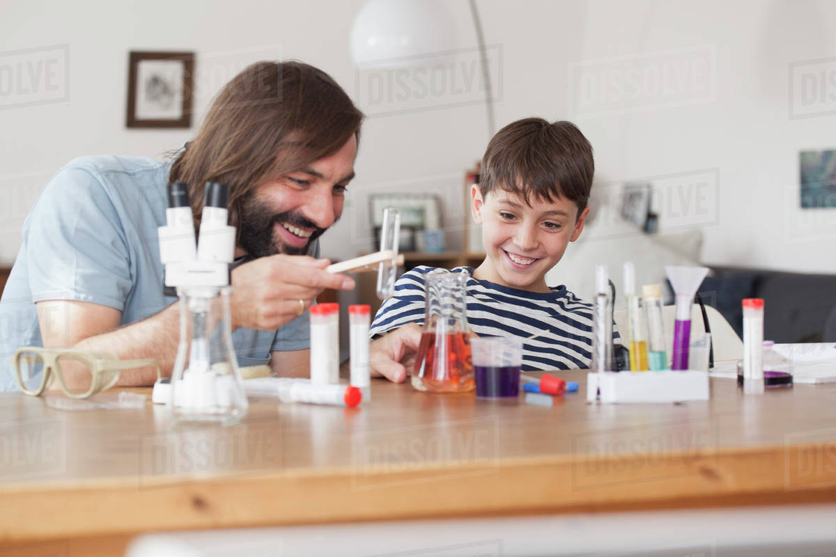 Father and son working on school science project at home - Stock Photo ...