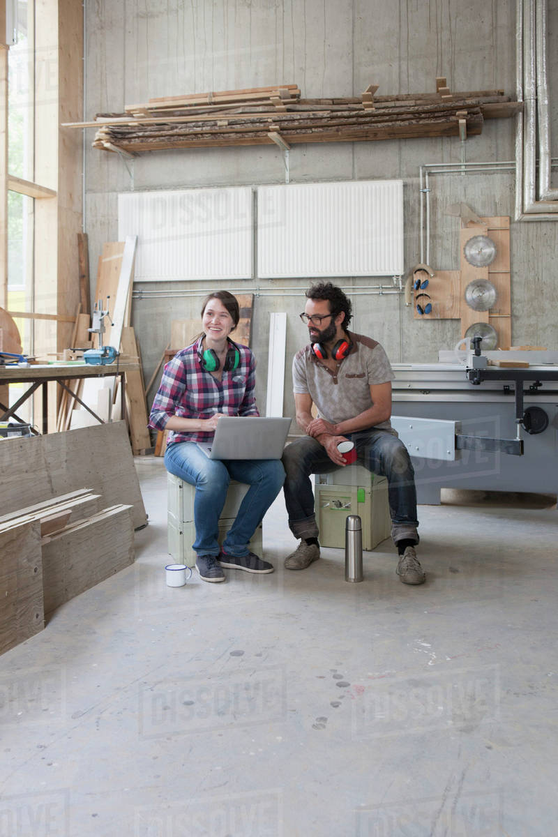 Full length of happy carpenters using laptop in workshop - Stock Photo ...