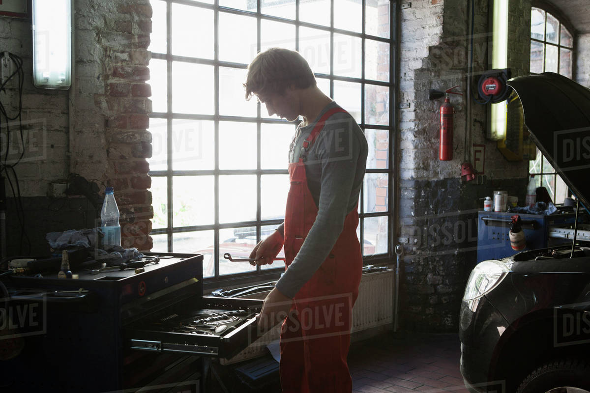 Side view of mechanic removing work tools from drawer at garage - Stock ...