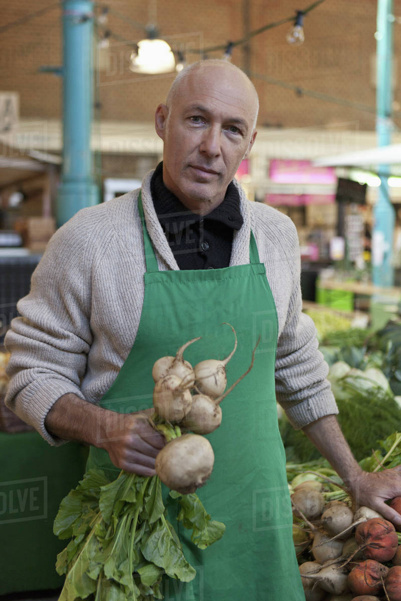 Mature man holding turnip, portrait - Stock Photo - Dissolve
