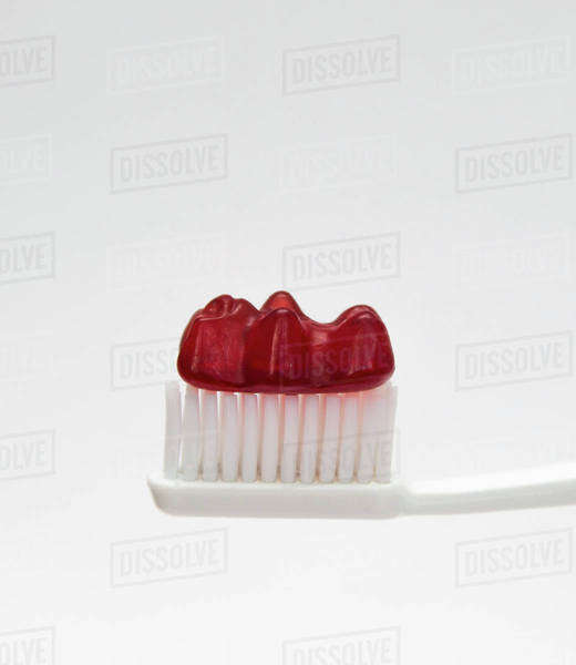 Close-up of gummy bear on toothbrush against white background - Stock ...