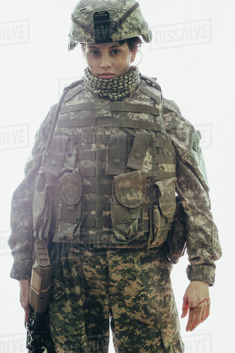 Portrait of army soldier carrying rifle standing against white ...