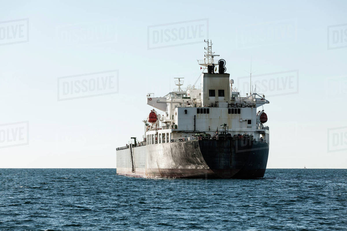 Cargo ship moving on sea against sky - Stock Photo - Dissolve