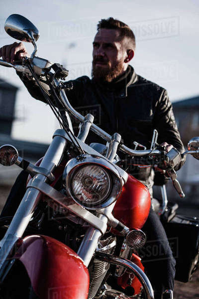 Portrait of biker sitting on motorcycle and looking away - Royalty-free ...