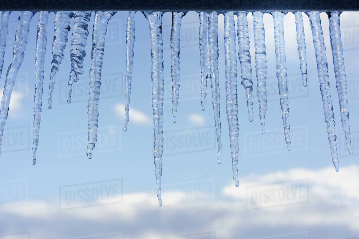 Close-up of icicles on roof edge - Royalty-free Stock Photo | Dissolve