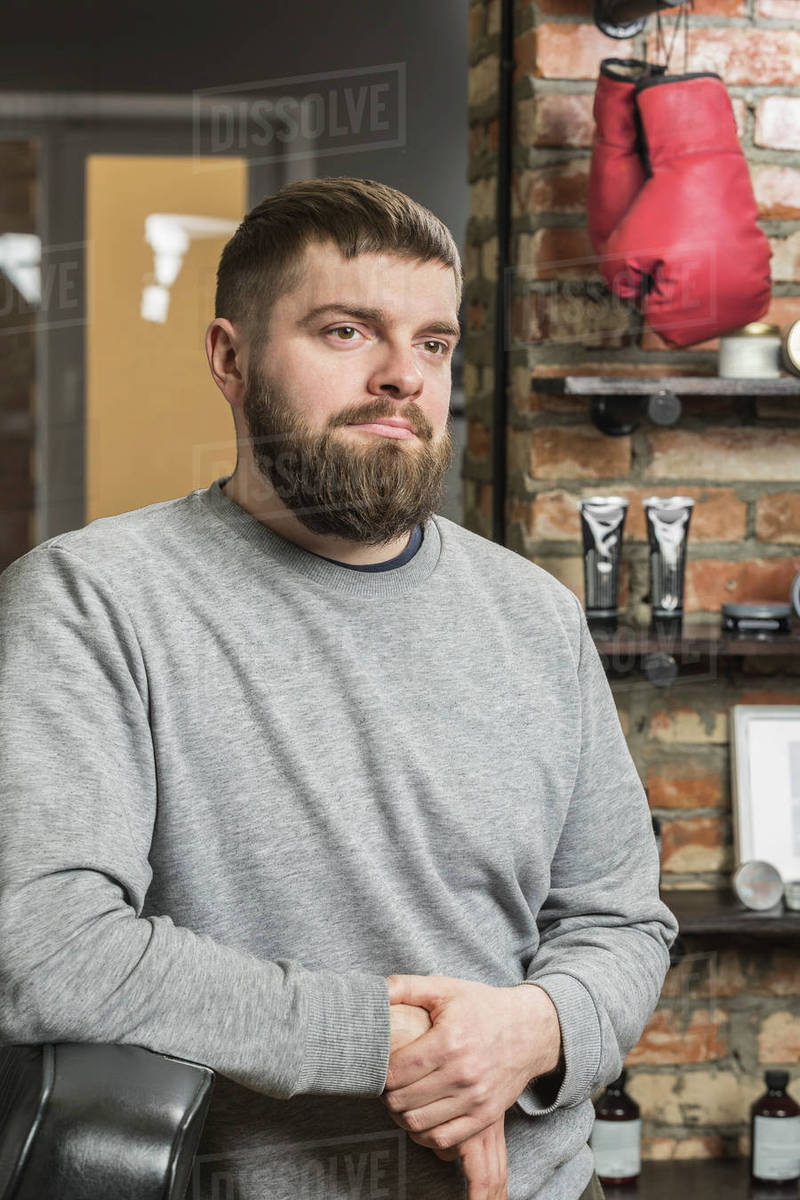 Confident male hairdresser standing by chair at hair salon - Royalty ...