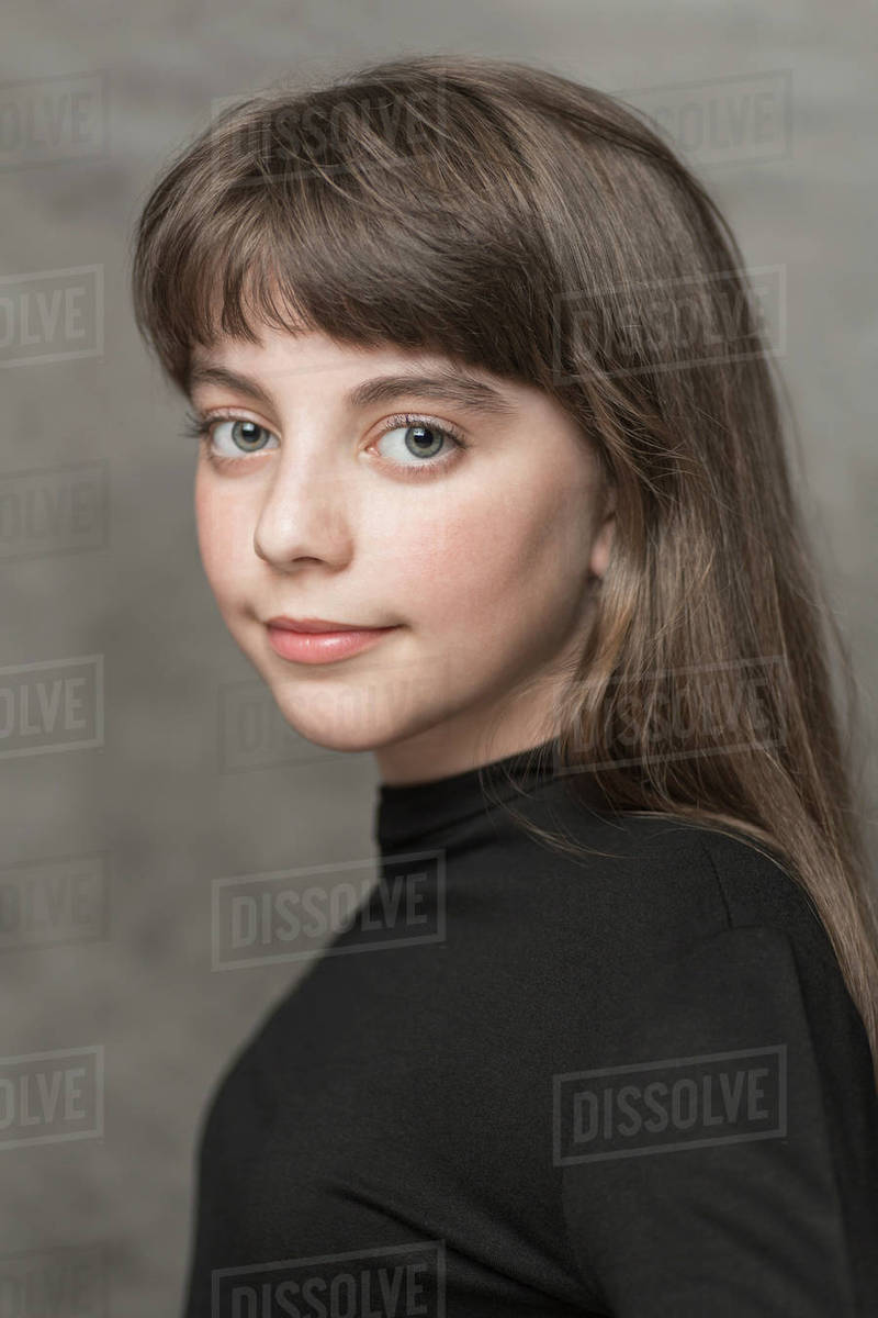 Side view portrait of smiling girl with long hair against gray ...