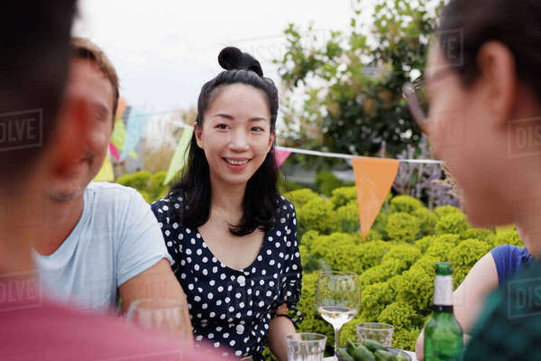 Happy young woman sitting with friends on patio - Royalty-free Stock ...