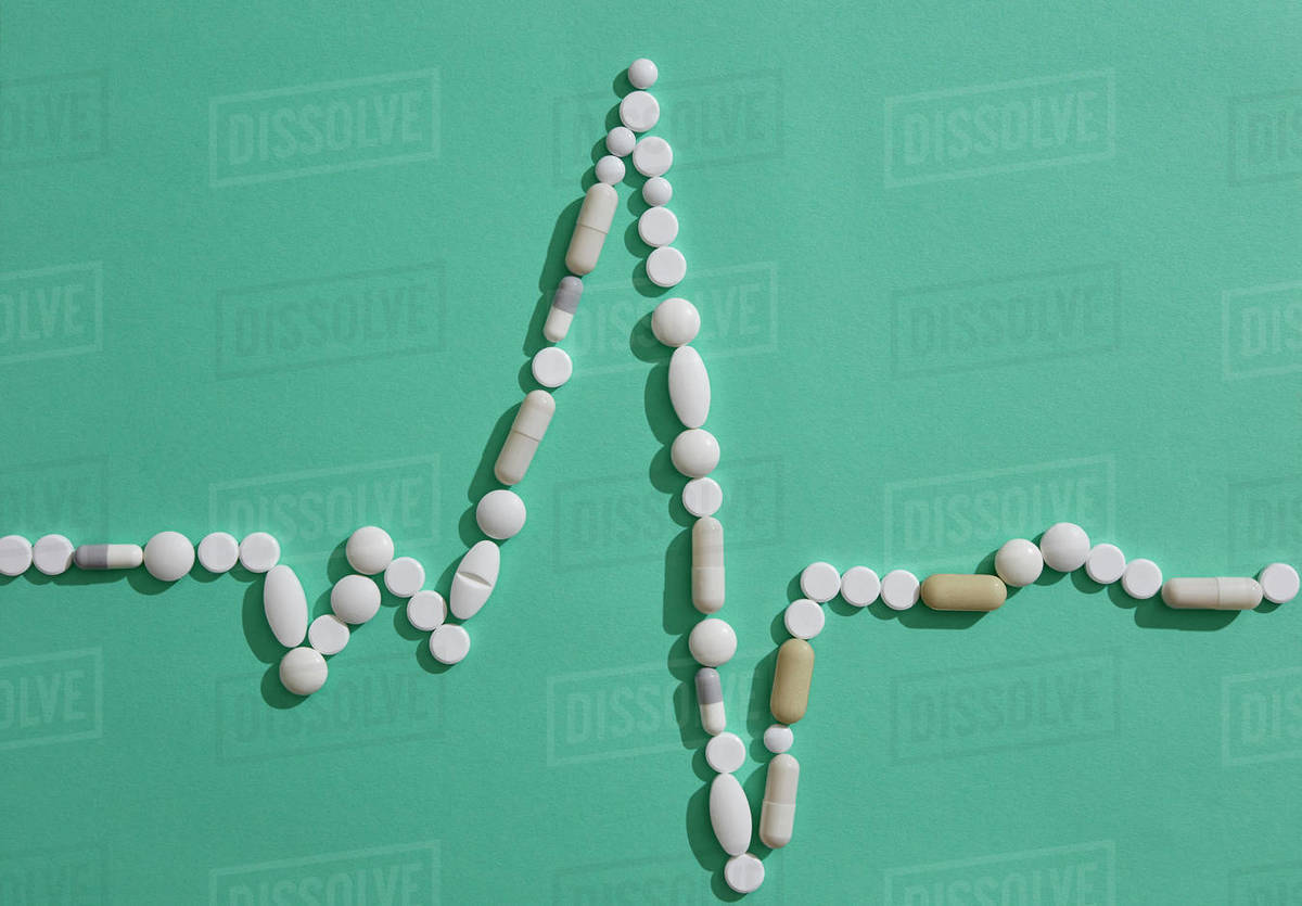 Pills forming pulse trace on green background - Stock Photo - Dissolve