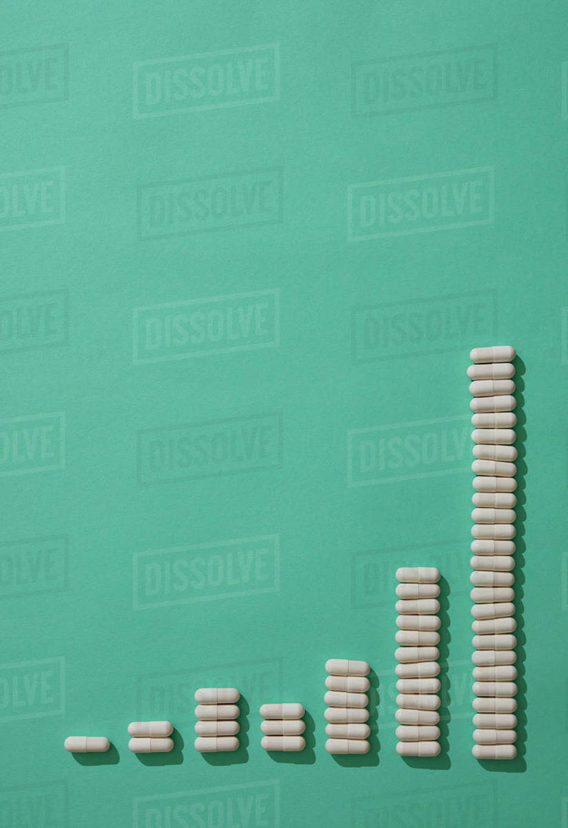 Capsules forming ascending bar graph on green background - Stock Photo ...