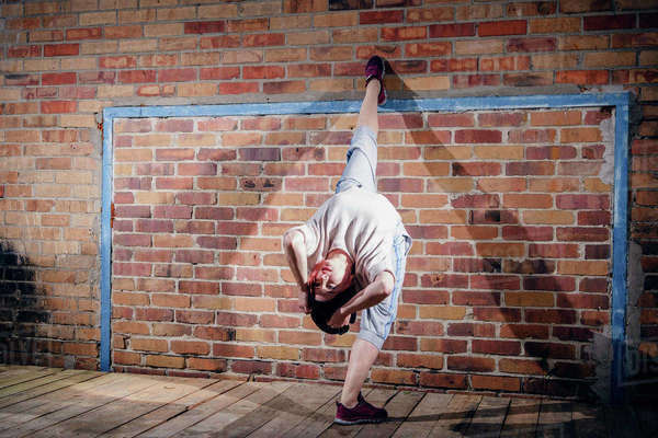 Female modern dancer performing against brick wall - Royalty-free Stock ...