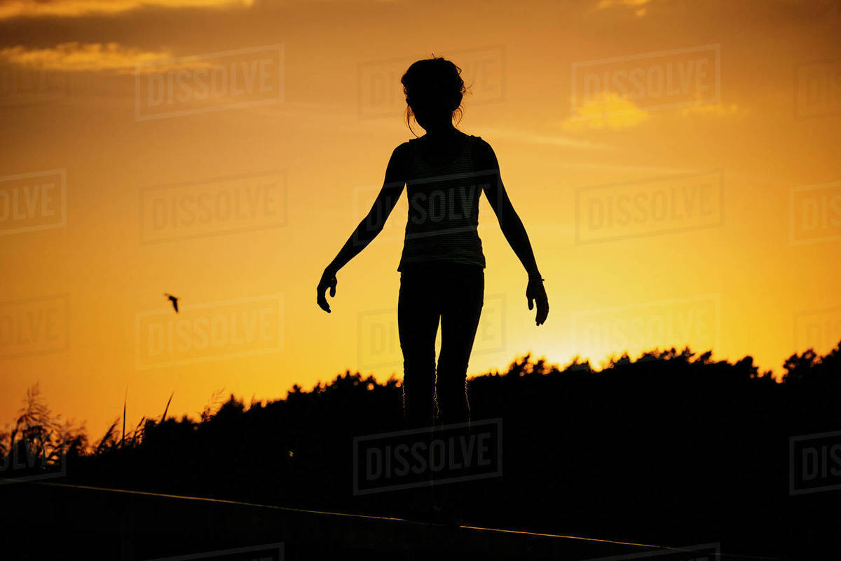 Silhouette woman standing against sunset sky - Royalty-free Stock Photo ...