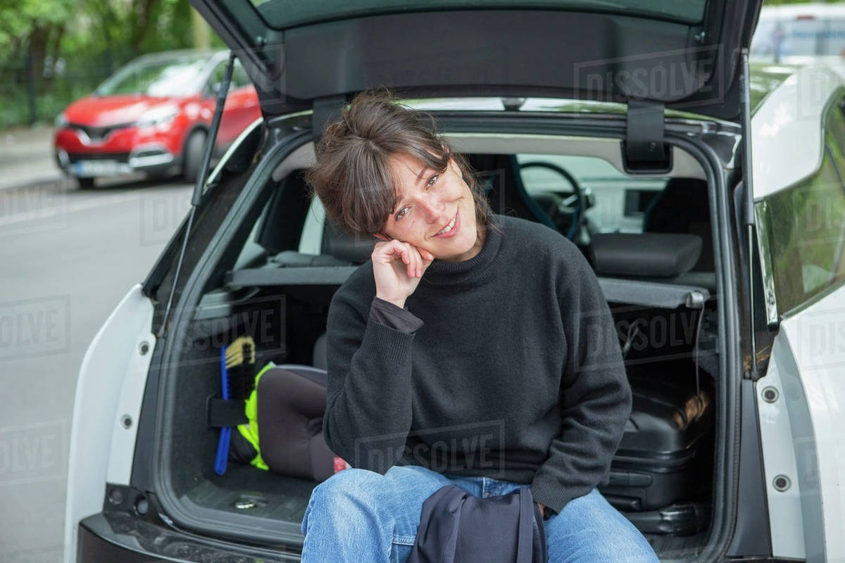 Portrait smiling young woman sitting at back of car - Royalty-free ...