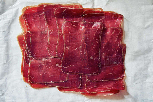 View from above sliced, air-dried Buendnerfleisch meat on butcher paper ...