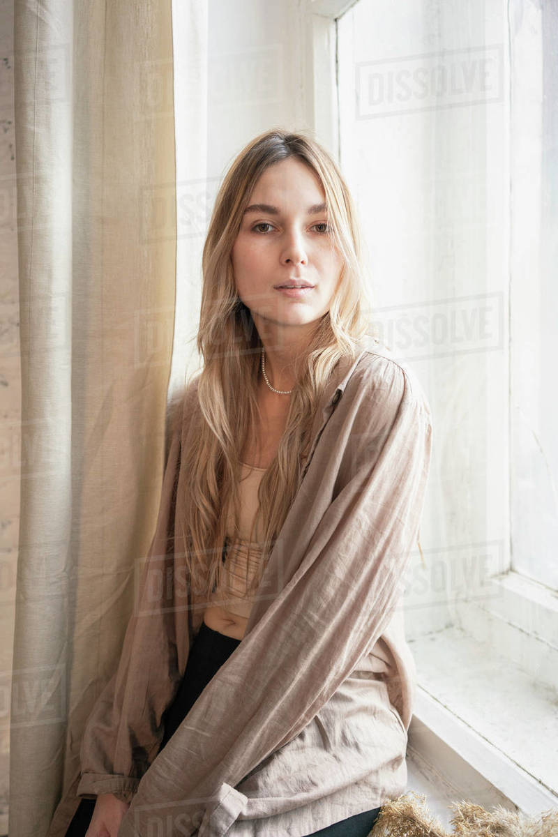 Portrait confident, beautiful young blonde woman in window - Stock ...
