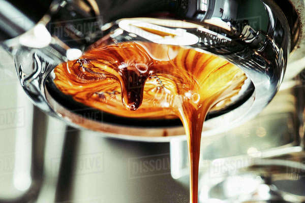 Close up espresso dripping from stainless steel portafilter - Stock ...