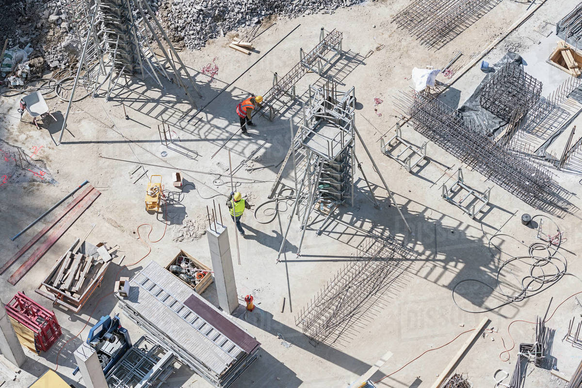 Aerial view construction workers working at sunny construction site ...