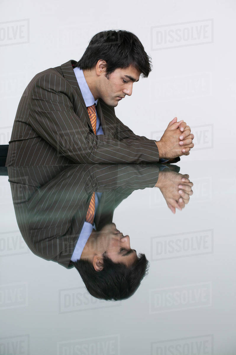 Reflection of thoughtful businessman in conference room table - Royalty ...