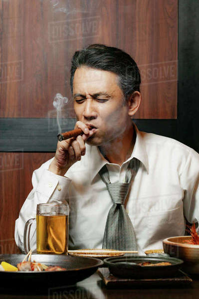 Businessman smoking cigar at lunch in restaurant - Royalty-free Stock ...