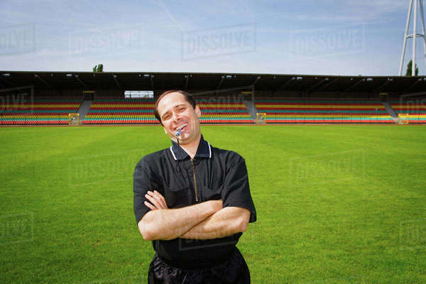 Portrait happy soccer coach with whistle on sunny pitch - Stock Photo ...