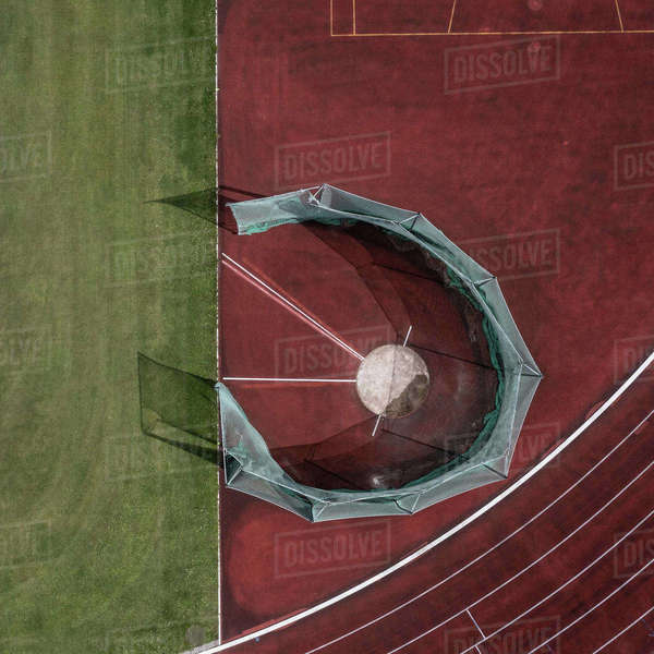 Aerial view fenced discus ring on red track in stadium infield ...