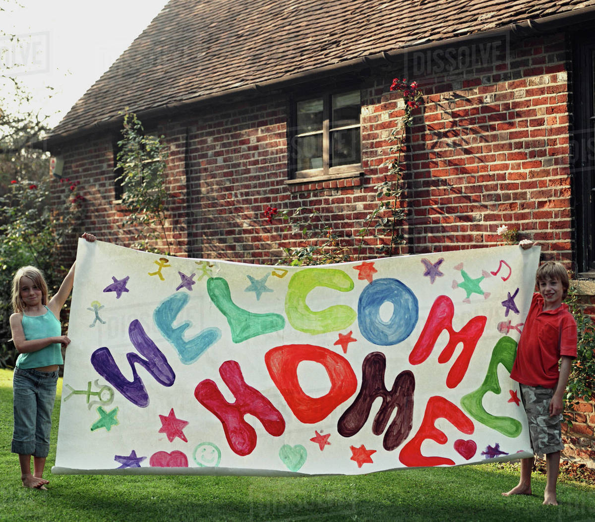 Portrait of two young children holding colorful welcome home sign ...