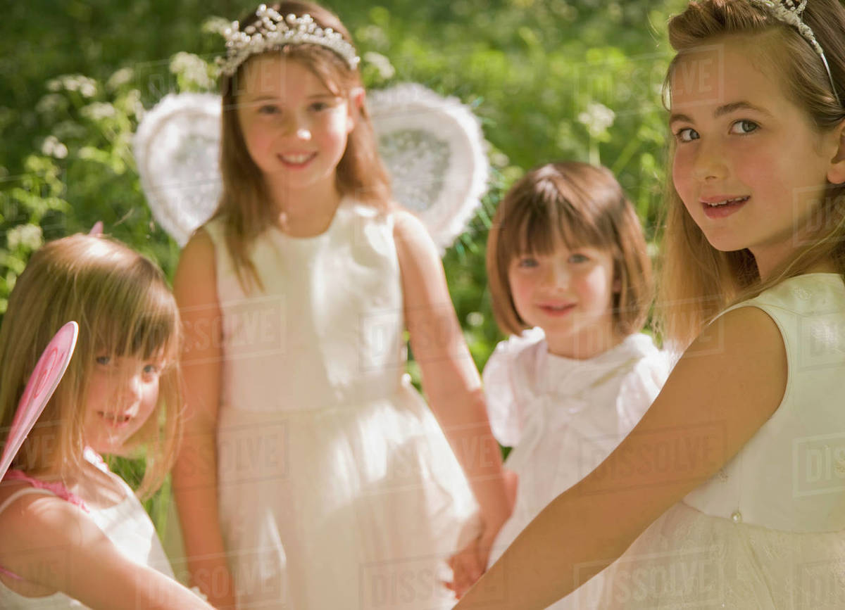 Young girls in fancy dress holding hands in a garden - Royalty-free ...