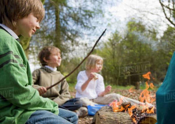 Children sitting around a campfire - Royalty-free Stock Photo | Dissolve