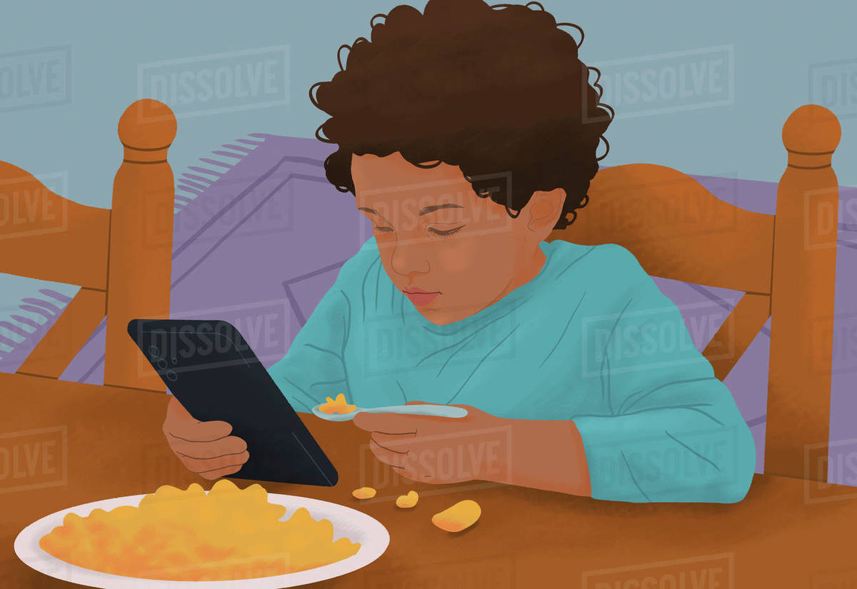 Messy, distracted boy eating macaroni and cheese and using smart phone ...