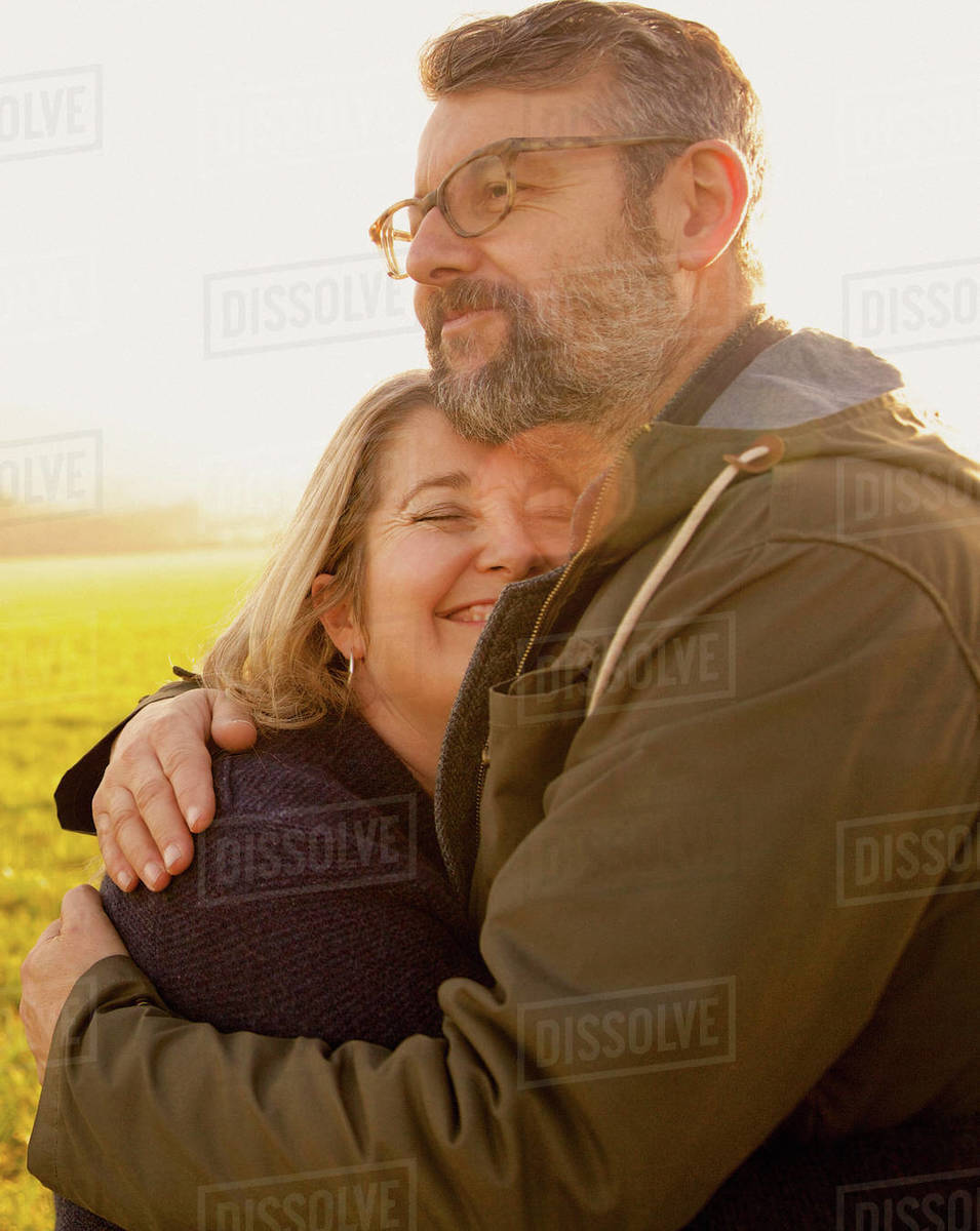 Couple Hugging in a Field - Stock Photo - Dissolve
