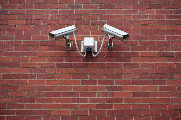 Video surveillance cameras on a wall - Stock Photo - Dissolve