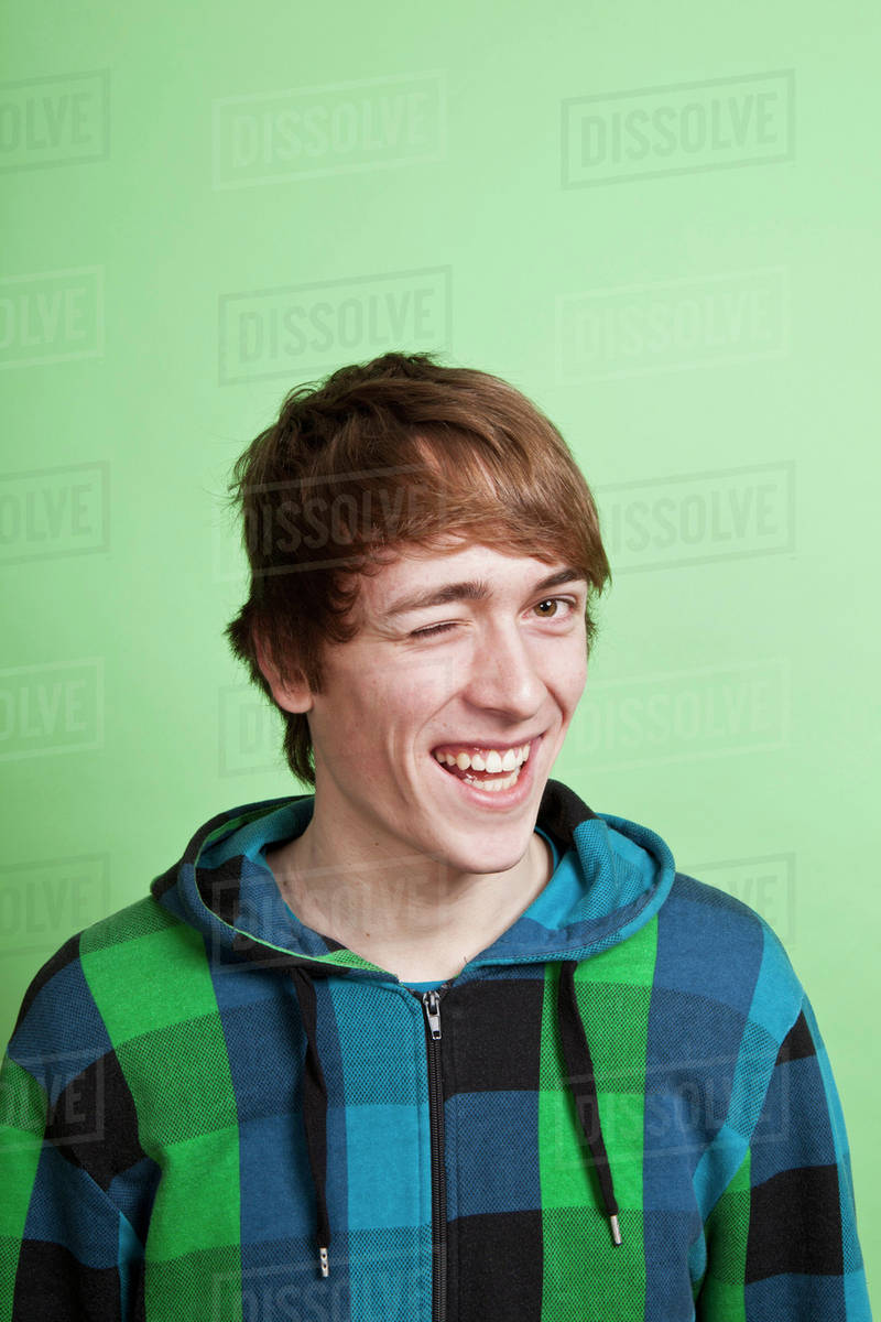 A teenage boy winking playfully, portrait, studio shot - Royalty-free ...