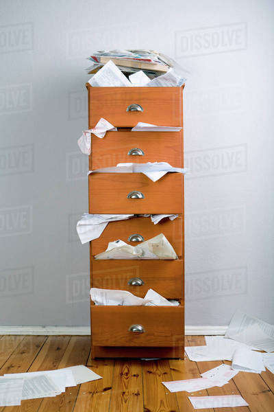 A cabinet stuffed with overflowing papers - Stock Photo - Dissolve