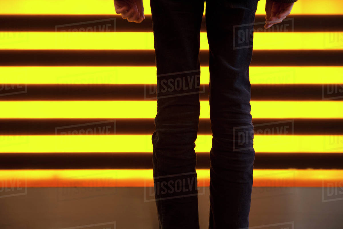 A man standing in front of lights, rear view, low section - Stock Photo ...