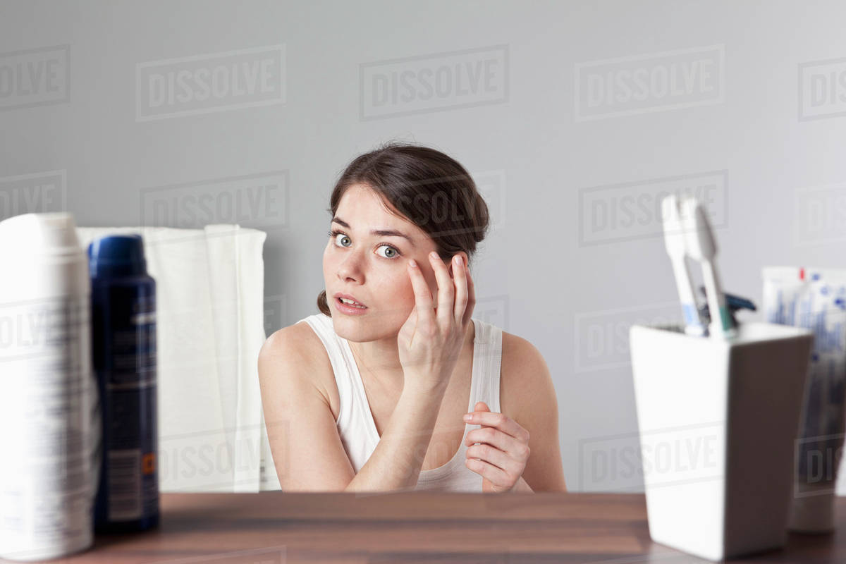 A woman inspecting her face - Royalty-free Stock Photo | Dissolve