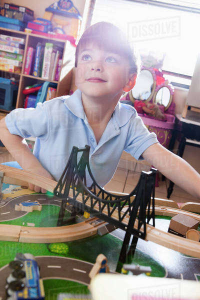 A boy playing with a train set - Stock Photo - Dissolve