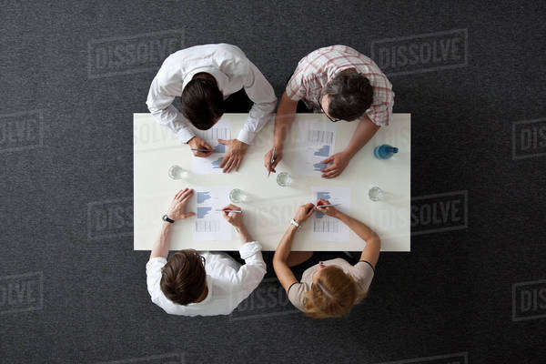A business meeting with three businessmen and a businesswoman, overhead ...